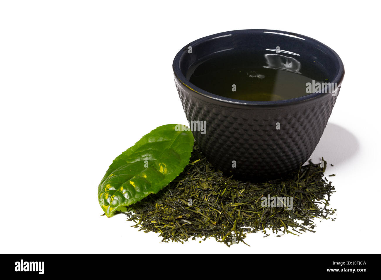 Iron cast cup and heap of green shincha tea, first flush, shadow tea ...