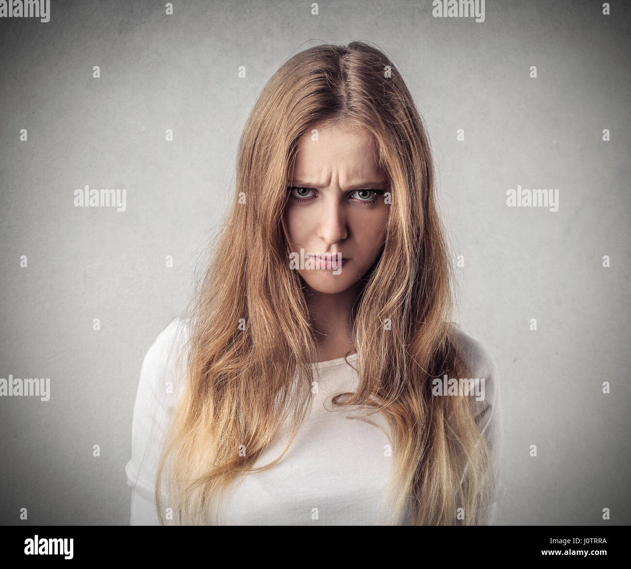 Blond woman looking angry at you Stock Photo - Alamy