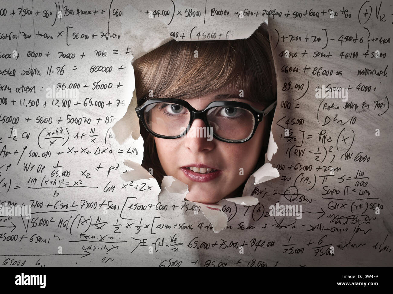 Woman breaking through paper full of math examples Stock Photo - Alamy