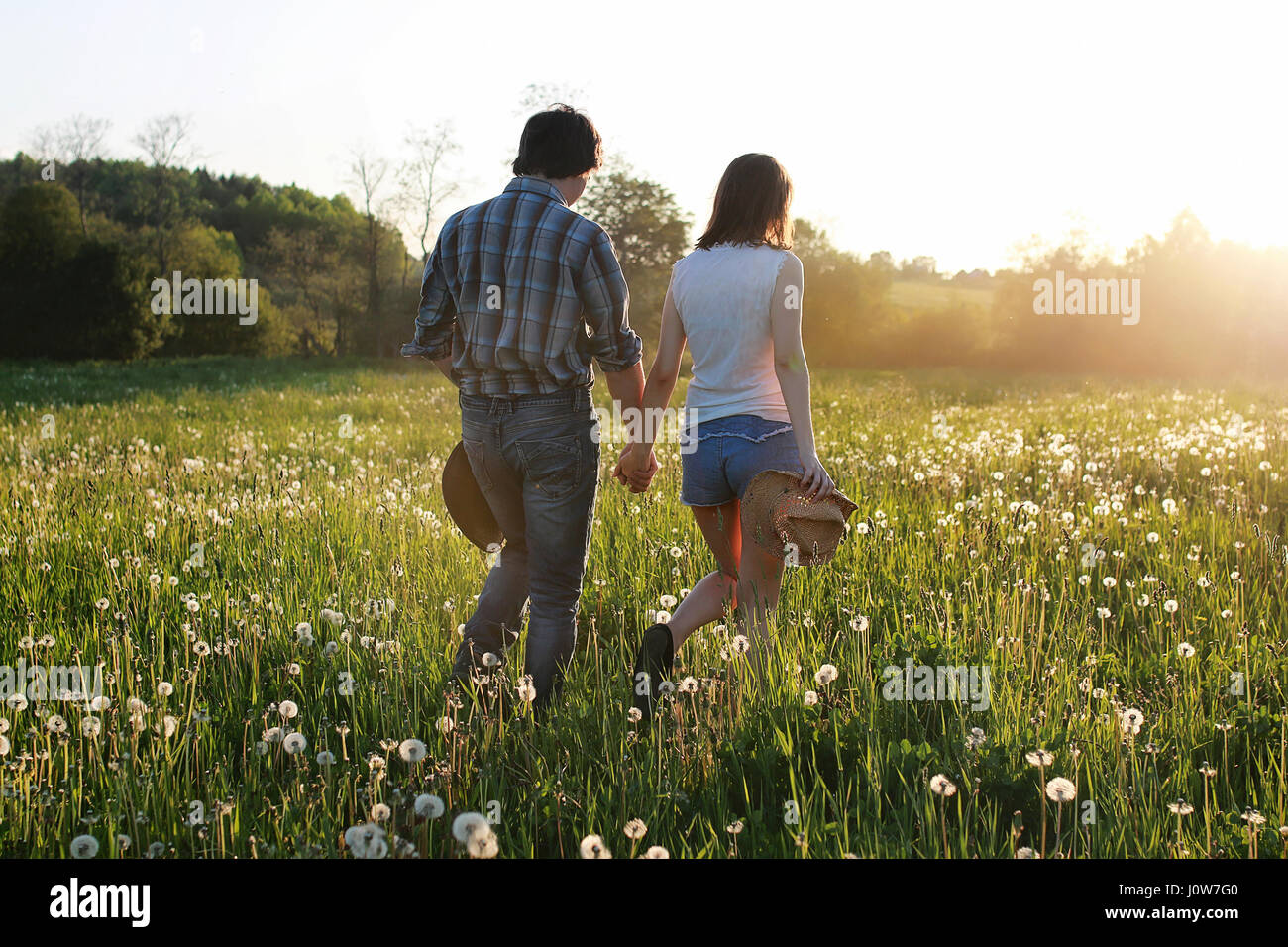 couple of young people walking in the sunset spring evening in a Stock Photo - Alamy