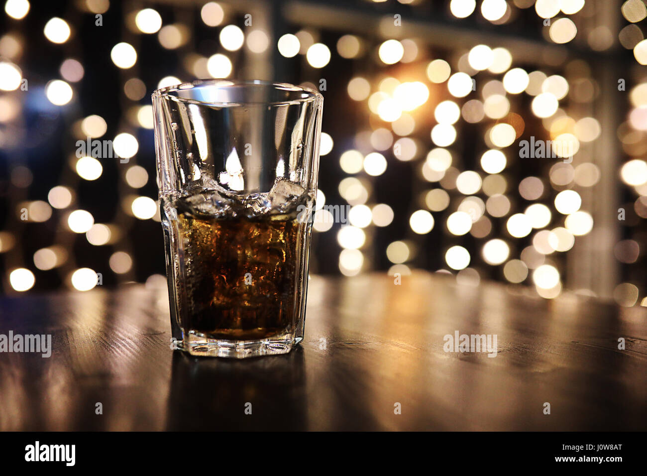 glass of alcohol with ice on blured background with circle bokeh Stock ...