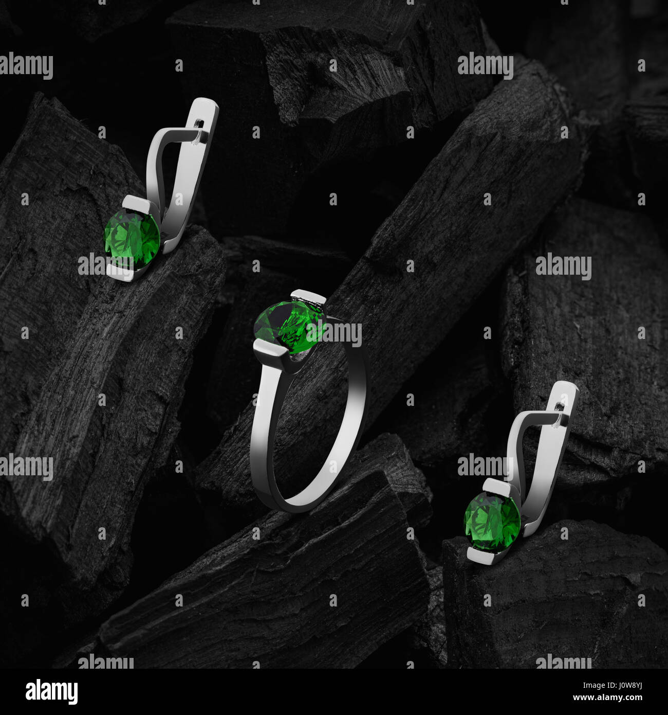 Ring and earrings with emeralds on the background of coal Stock Photo ...