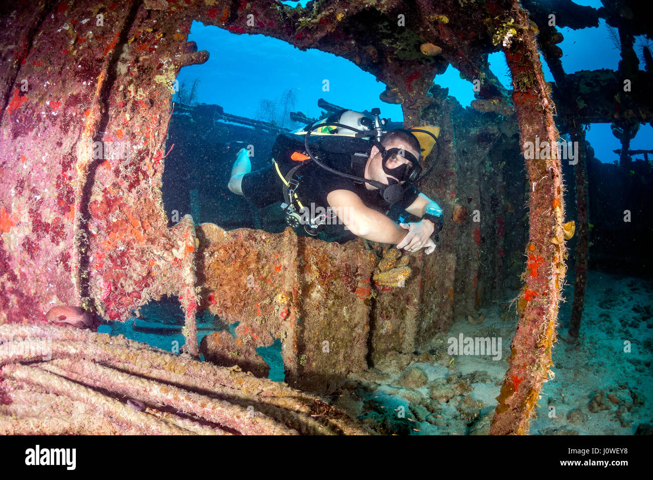 SCUBA diver swimming through an old underwater shipwreck Stock Photo ...