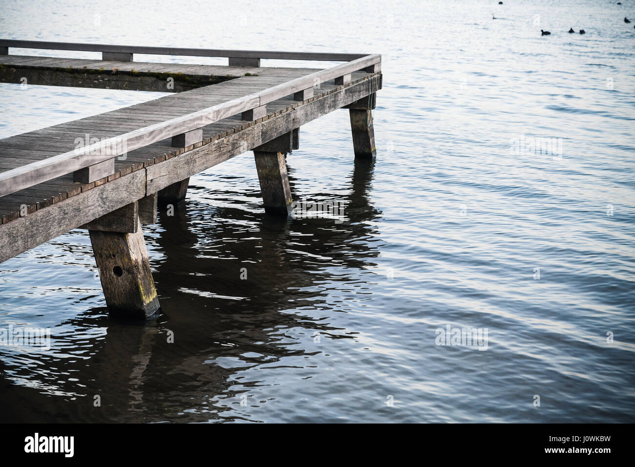 Corner of old wooden pier and blue lake water, background photo Stock ...