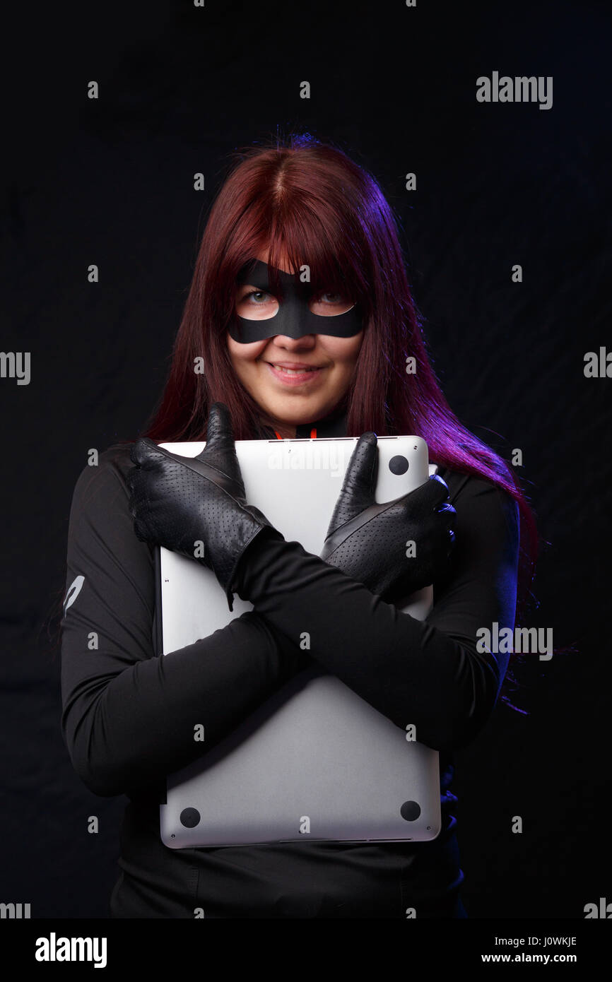 Woman hacker cuddles stolen laptop Stock Photo - Alamy