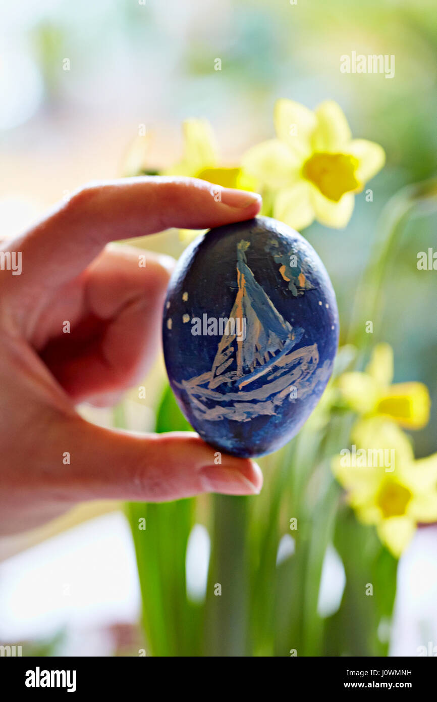 Easter painted egg. White painted ship on the blue ocean painted on ...