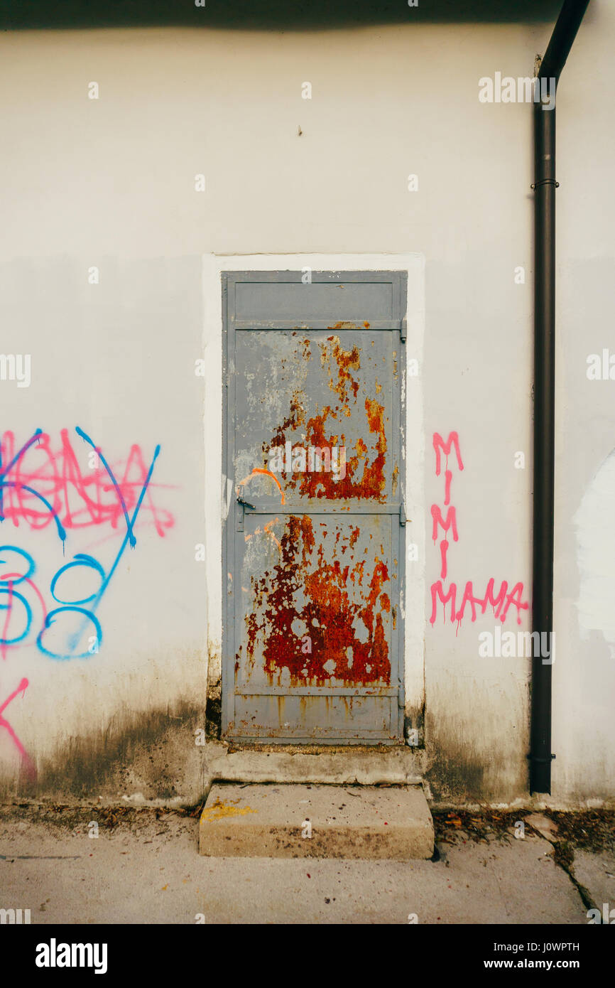 Gray metal entrance door in red rust, white wall, small step Stock ...