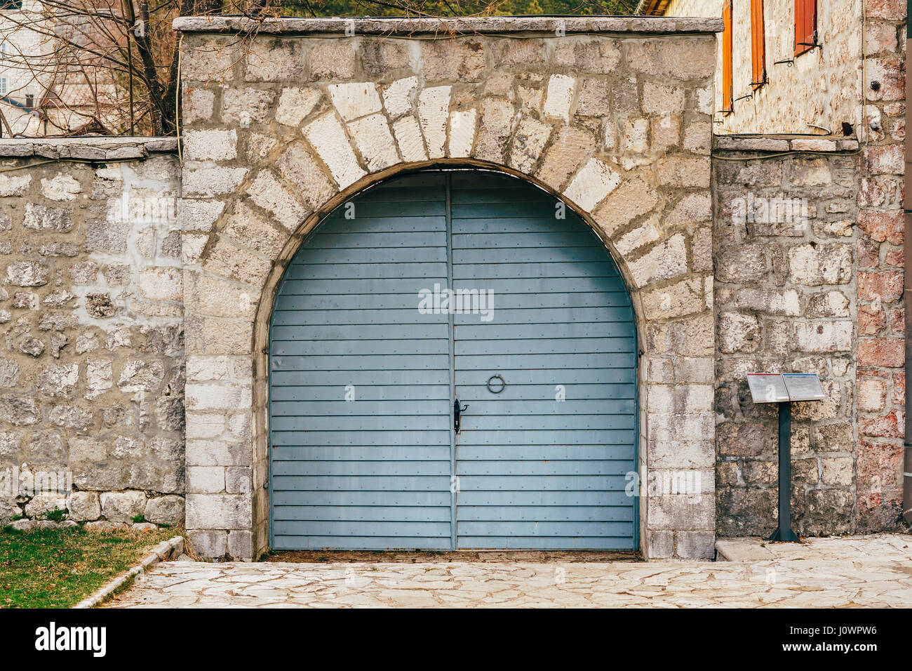 A blue-gray metal gate in a stone fence. Texture of metal Stock Photo ...