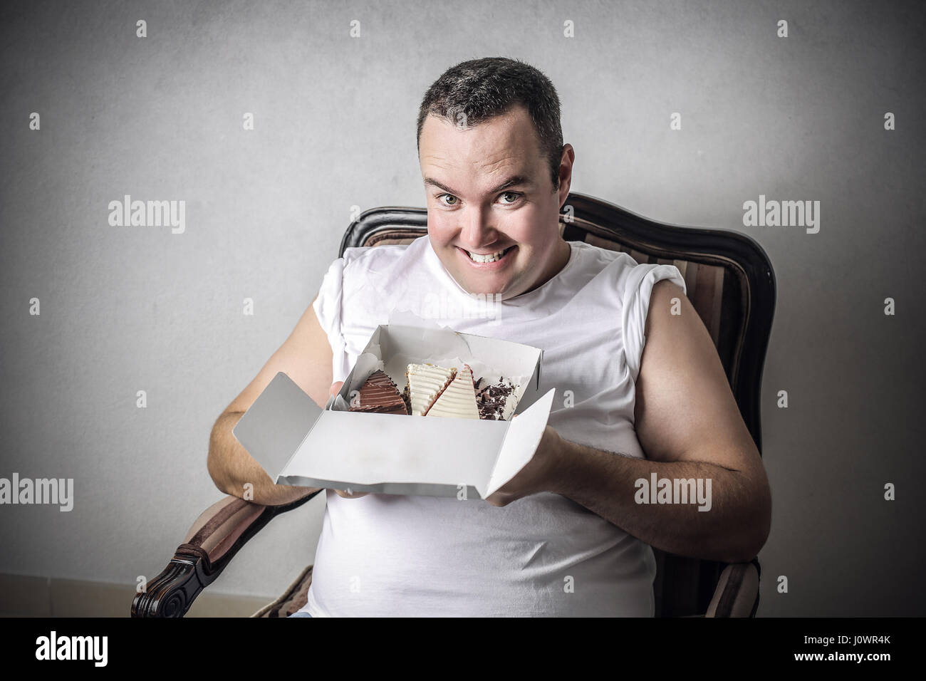 Happy fat man eating chocolate hi-res stock photography and images - Alamy