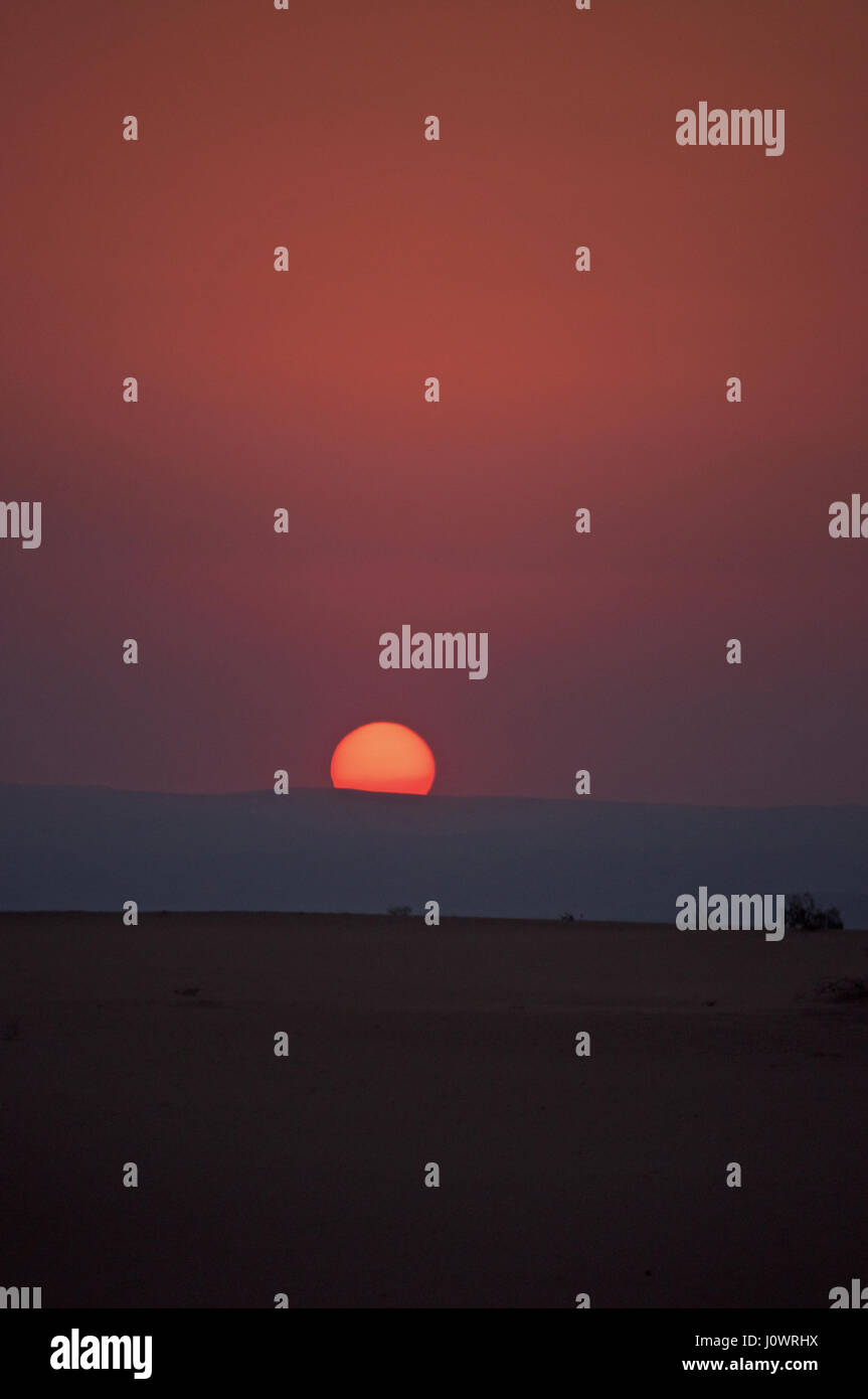 Jordan fiery sunset in the desert landscape on the road to the Dead Sea ...