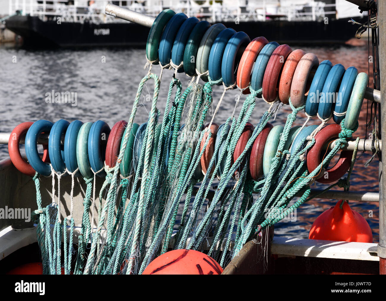 Brightly coloured annular plastic net floats on a fishing boat in ...