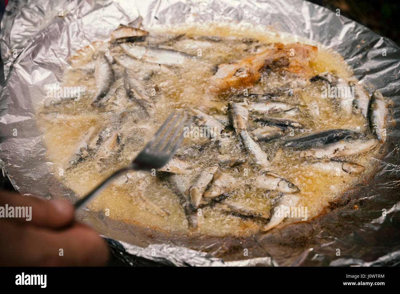 frying small fish in oil, close up Stock Photo - Alamy