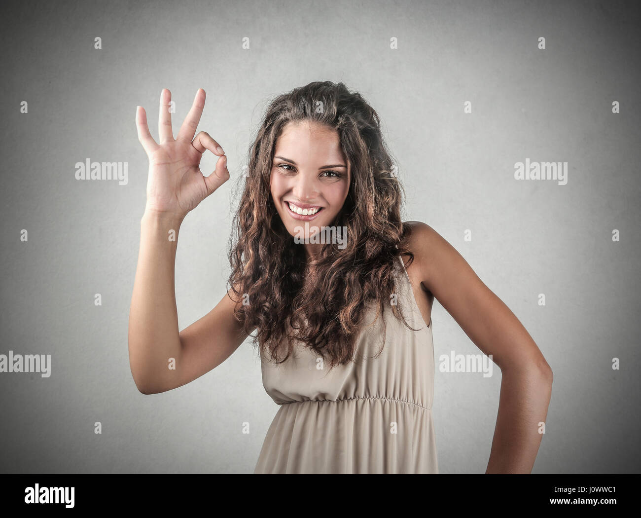 Brunette woman showing perfect sign Stock Photo - Alamy