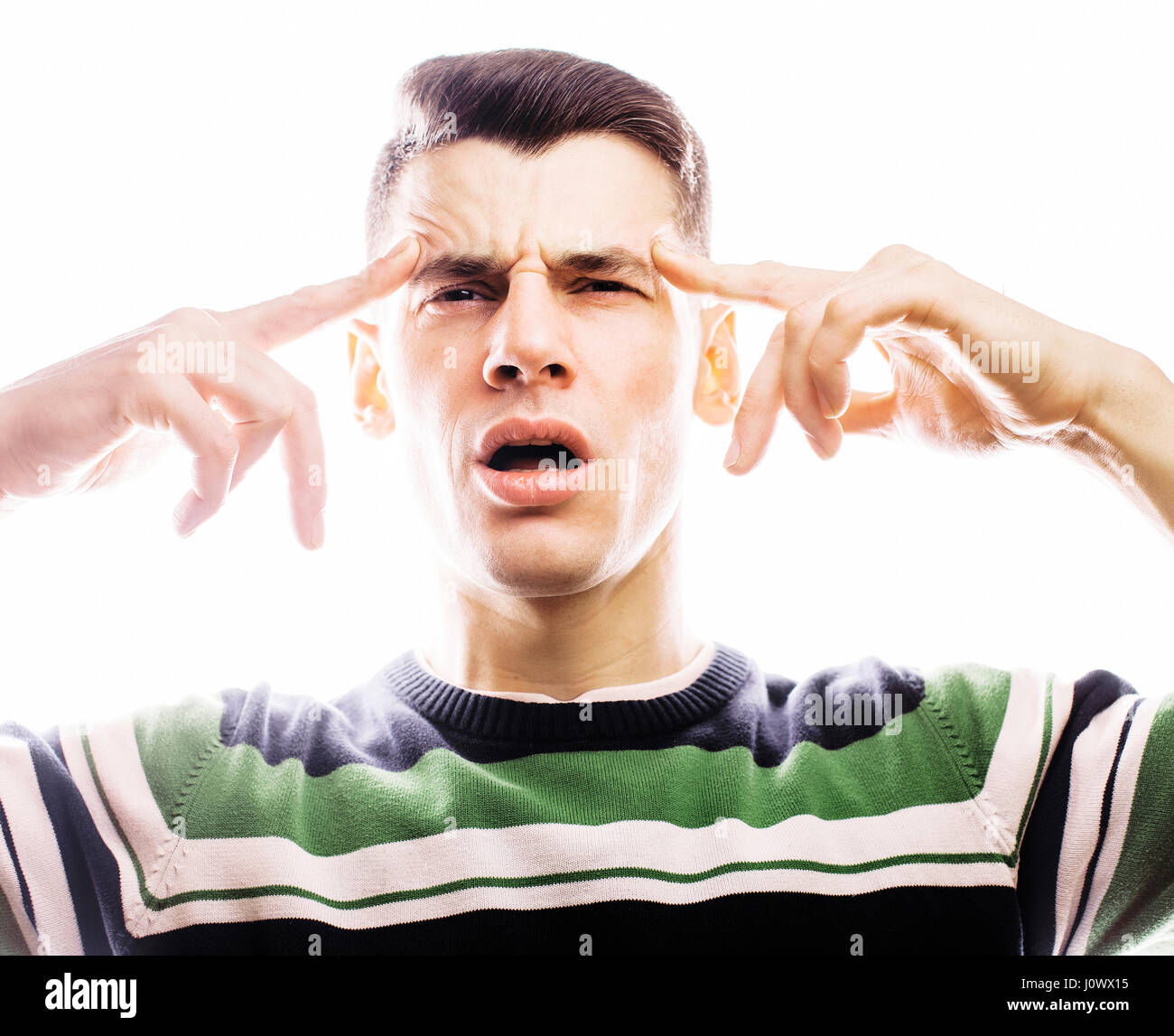 Portrait of a smart serious young man standing against white background ...