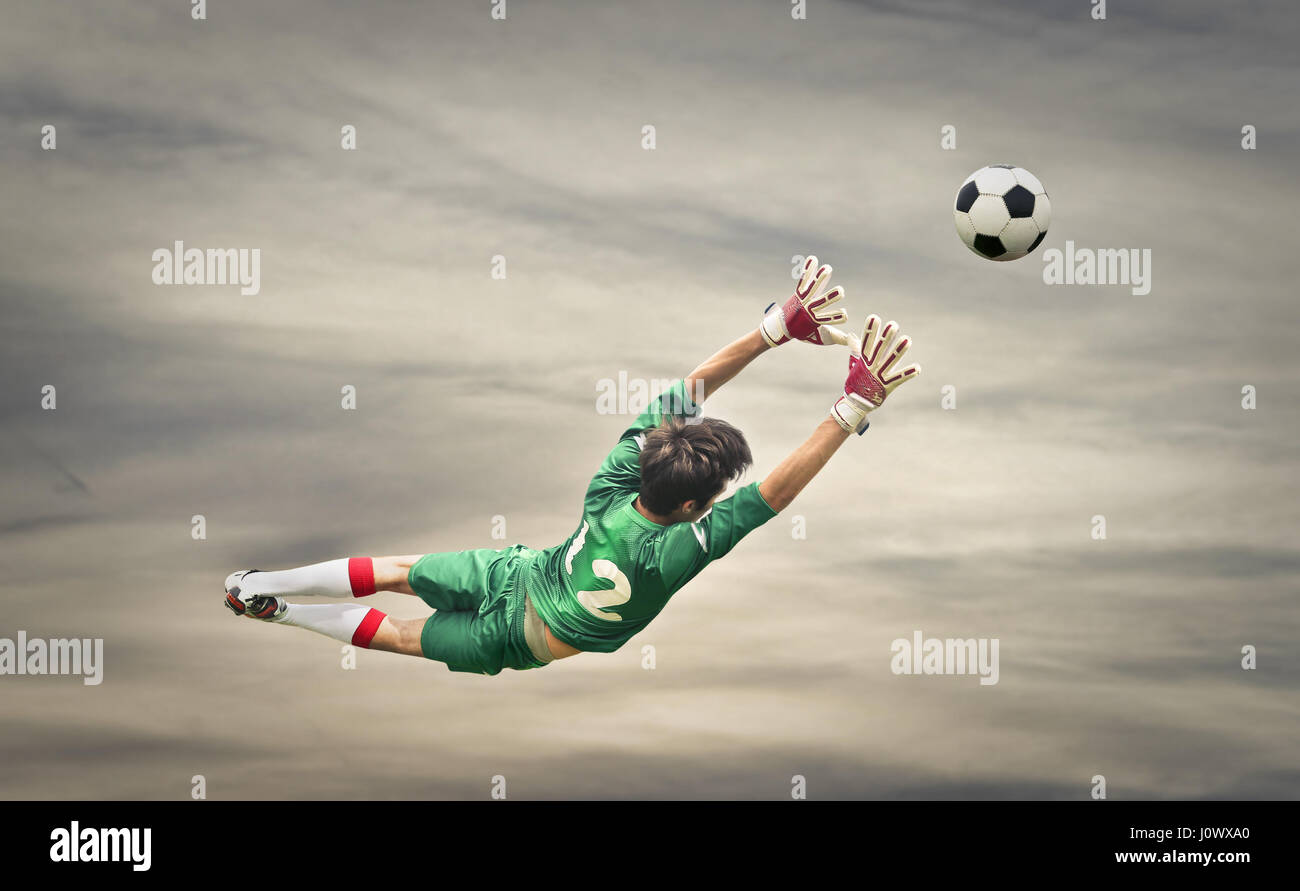 Footballer catching ball Stock Photo - Alamy