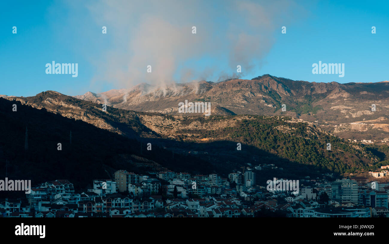 Fire in the mountains in the afternoon. Smoke over the mountains. Budva ...