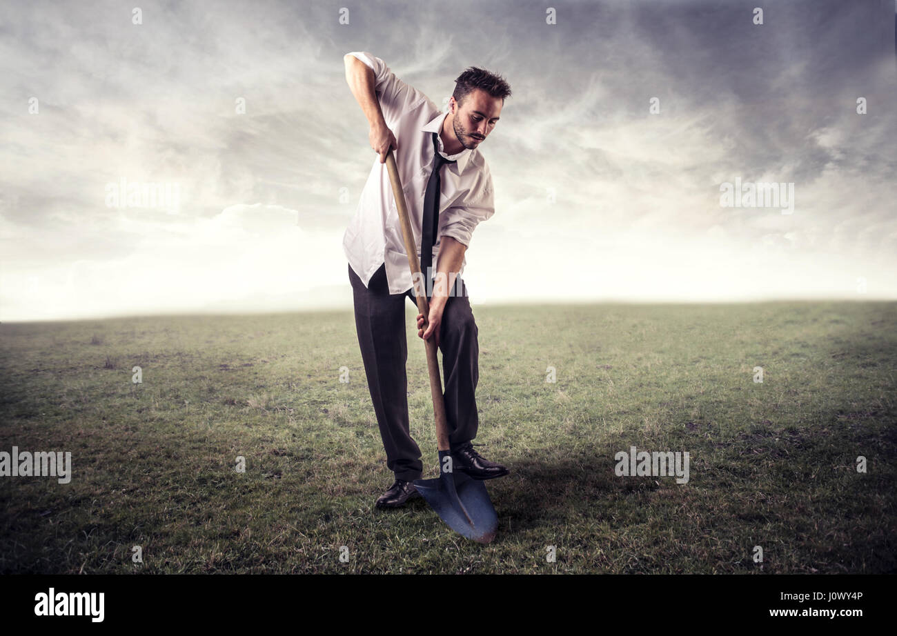 Businessman digging outside Stock Photo - Alamy