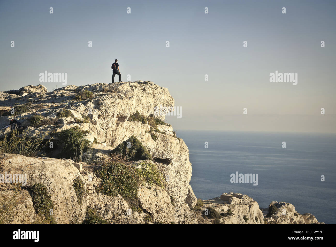 Man standing on cliff Stock Photo - Alamy