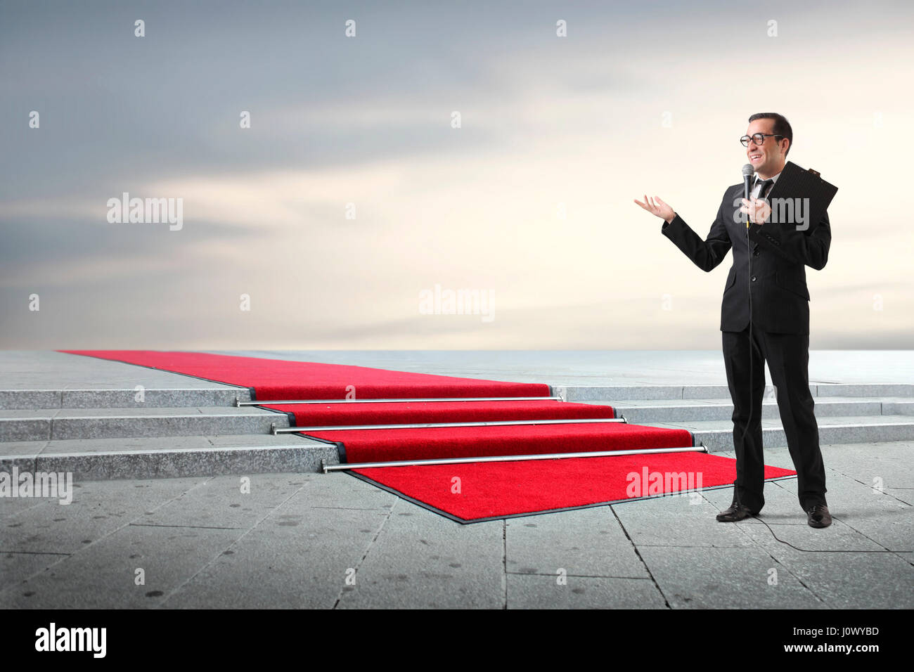 Presenter man next to red carpet Stock Photo - Alamy