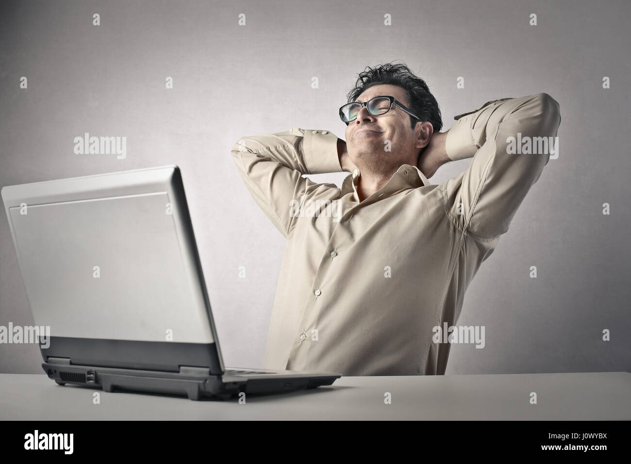 Businessman relaxing in front of laptop Stock Photo - Alamy