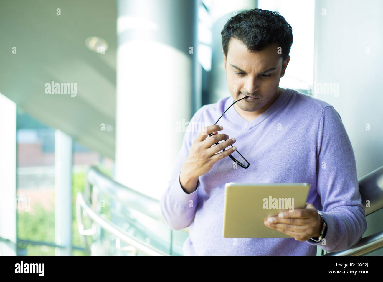 Closeup portrait, young captivated, absorbed, engrossed man in purple ...