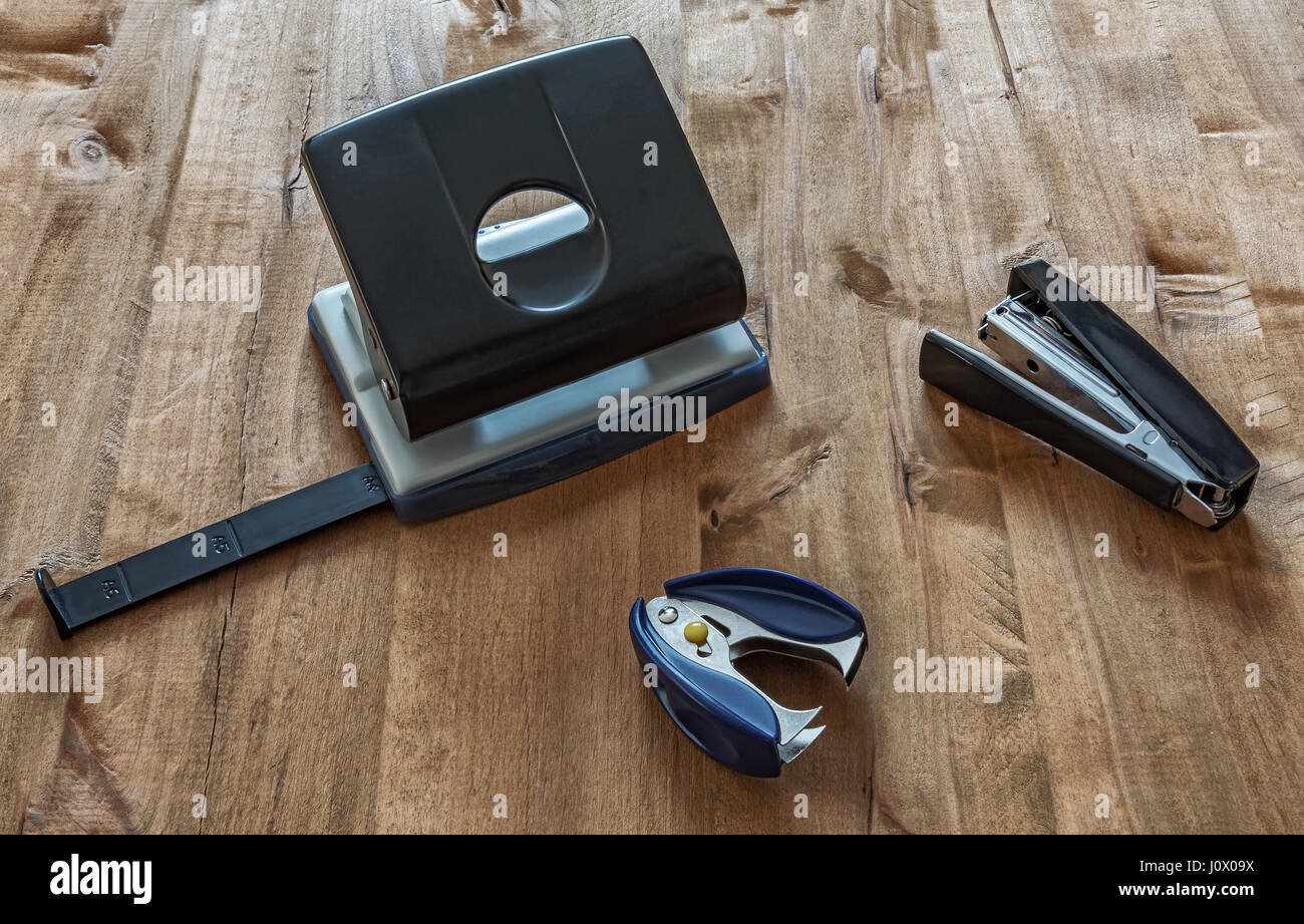On the wooden surface are a stapler, anti-stapler and puncher Stock ...