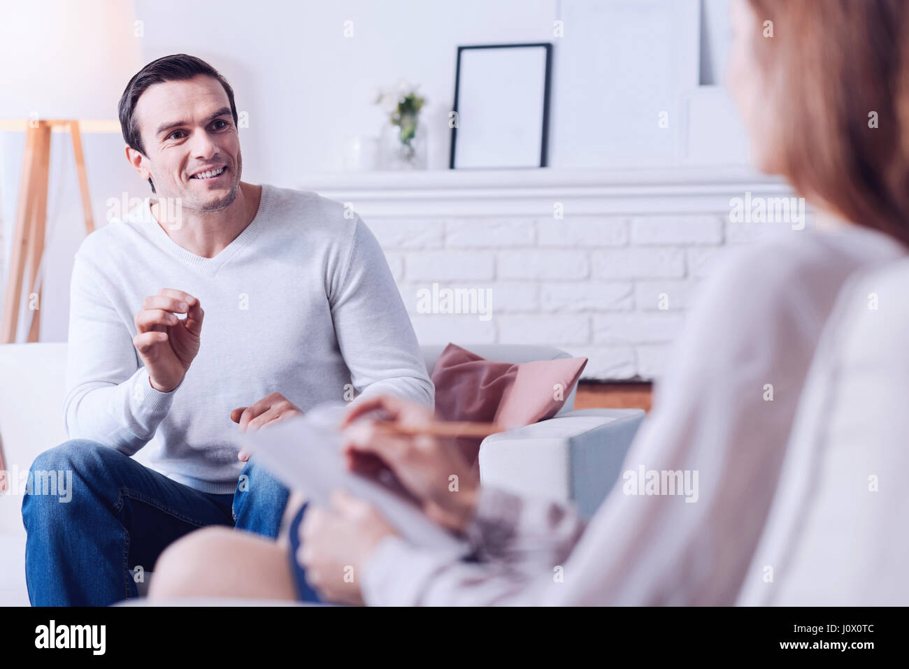 Joyful handsome man talking with psychologist Stock Photo - Alamy