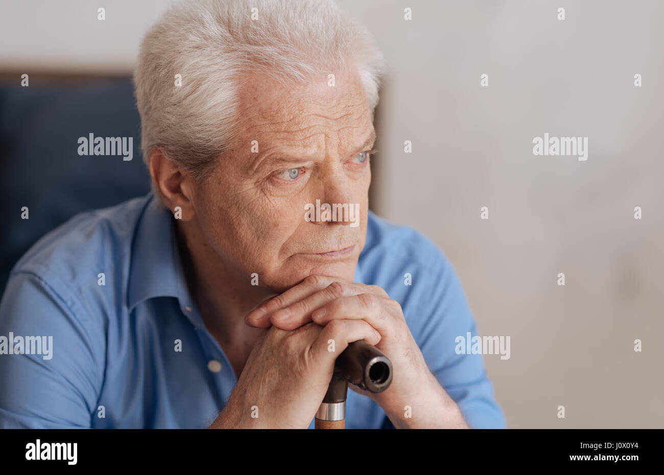 Old times. Portrait of a sad thoughtful senior man holding a walking ...