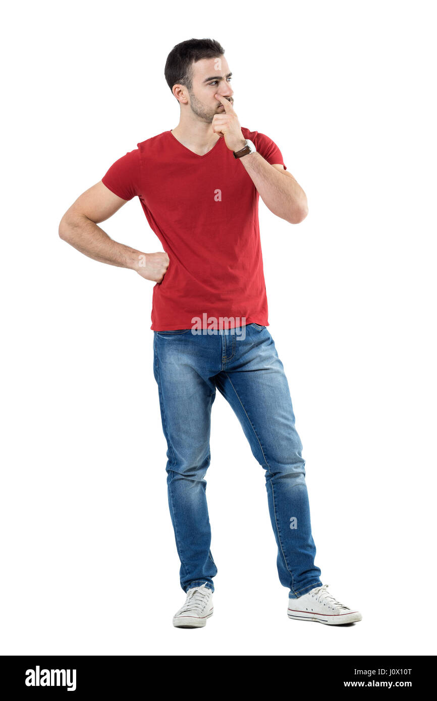 Worried young casual man thinking and looking away with hand on chin ...