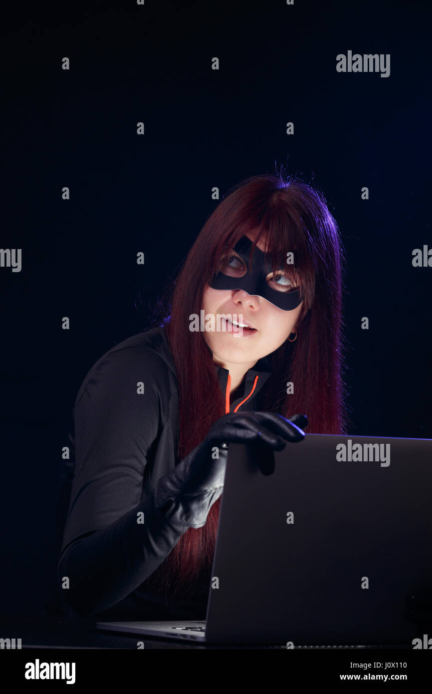 Thief in mask with laptop Stock Photo - Alamy