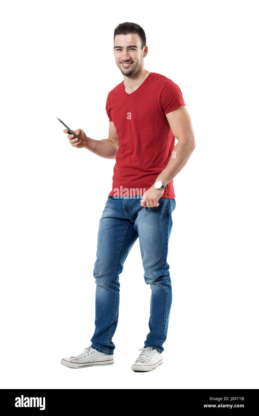 Laughing young man holding mobile phone reading humorous message. Full ...