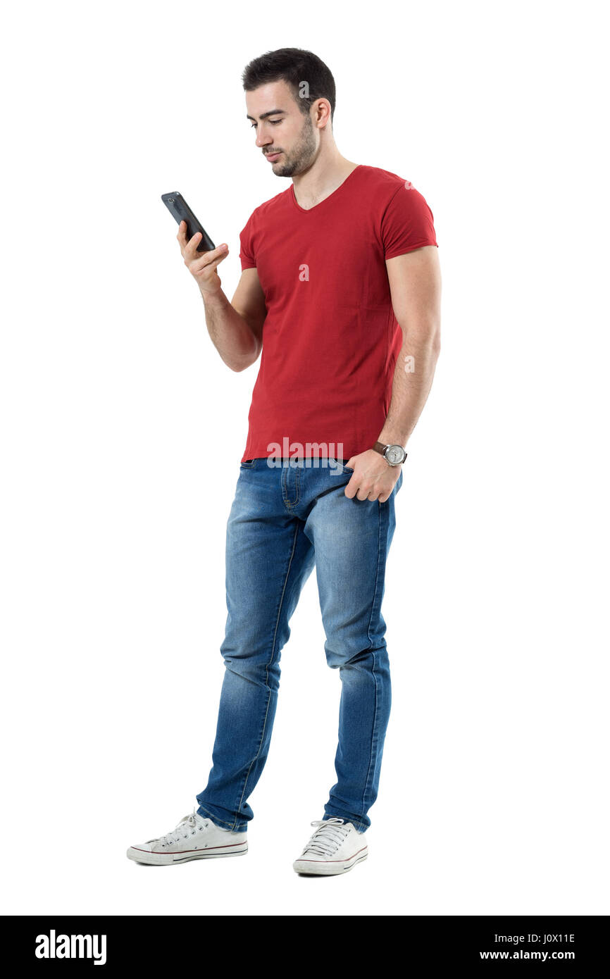 Relaxed young casual man reading text message on mobile phone. Full ...