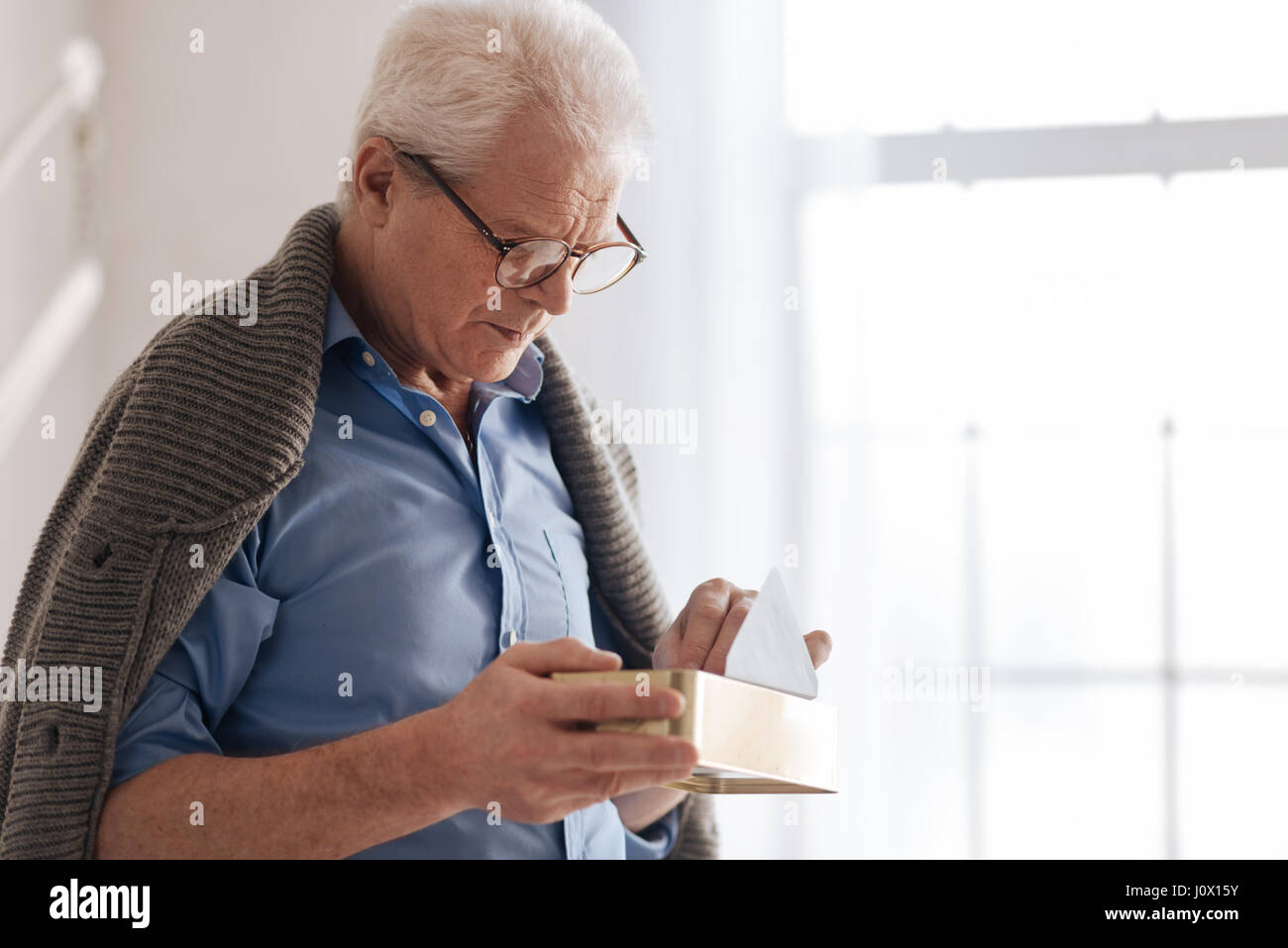 Depressed aged man putting old letters in the box Stock Photo - Alamy