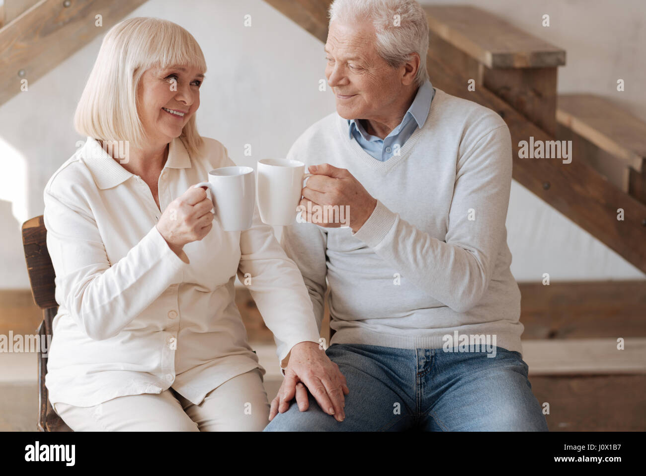 Positive delighted couple clinking cups Stock Photo - Alamy