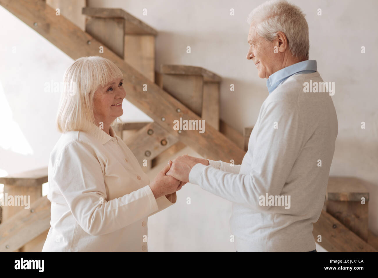 Cheerful elderly couple holding hands together Stock Photo - Alamy
