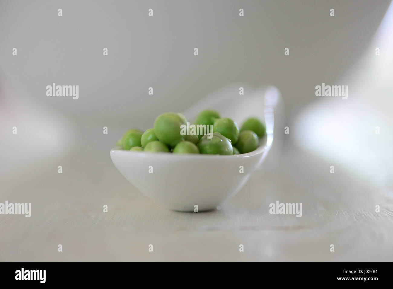 Spoon with peas Stock Photo - Alamy