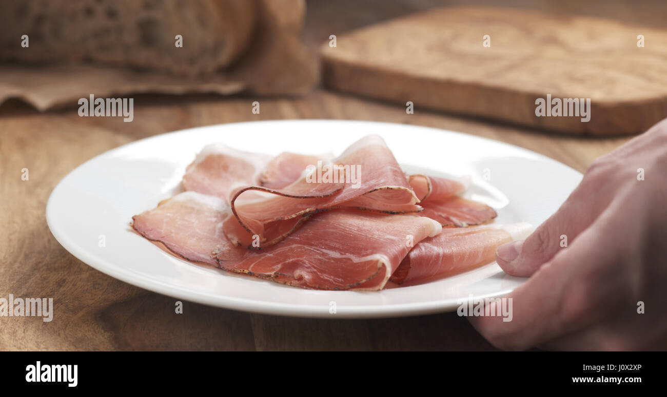 Italian speck ham on a plate put on table Stock Photo - Alamy