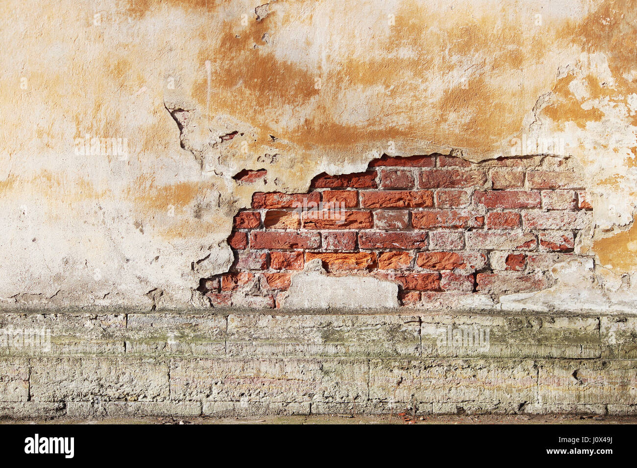 The texture of the old bricks and beige plaster of the historic house ...