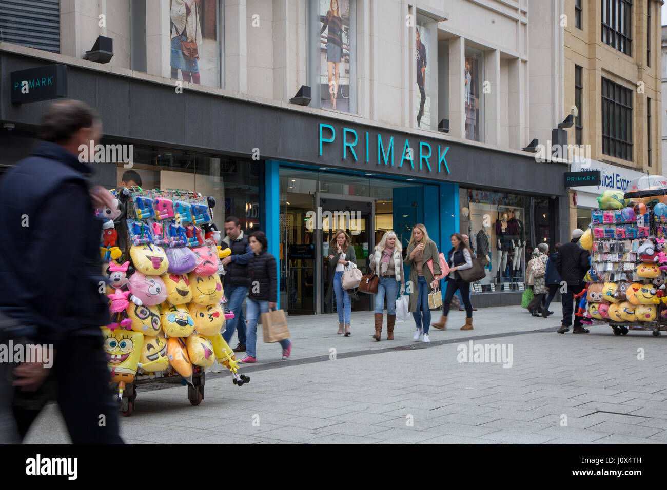 Primark on Queen Street, Cardiff. Vendors in the foreground are selling ...