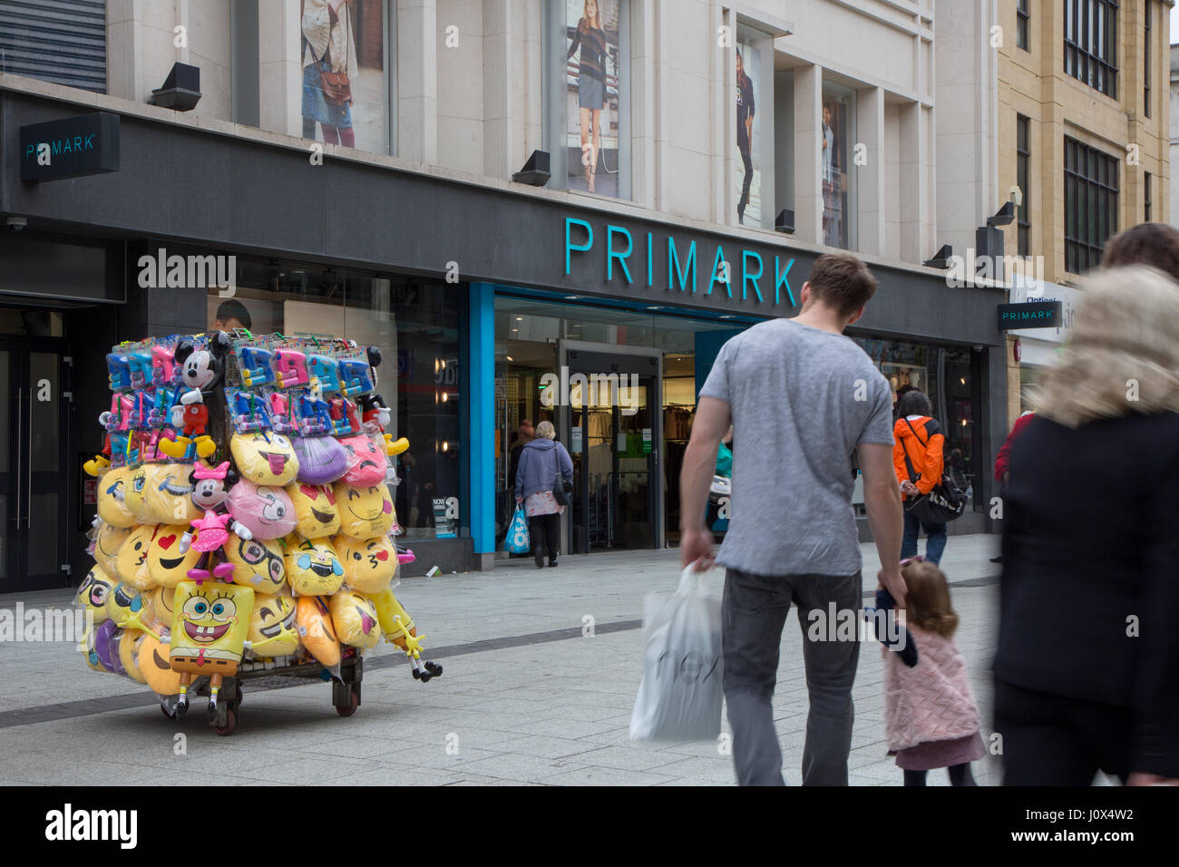 Primark on Queen Street, Cardiff. Vendors in the foreground are selling ...