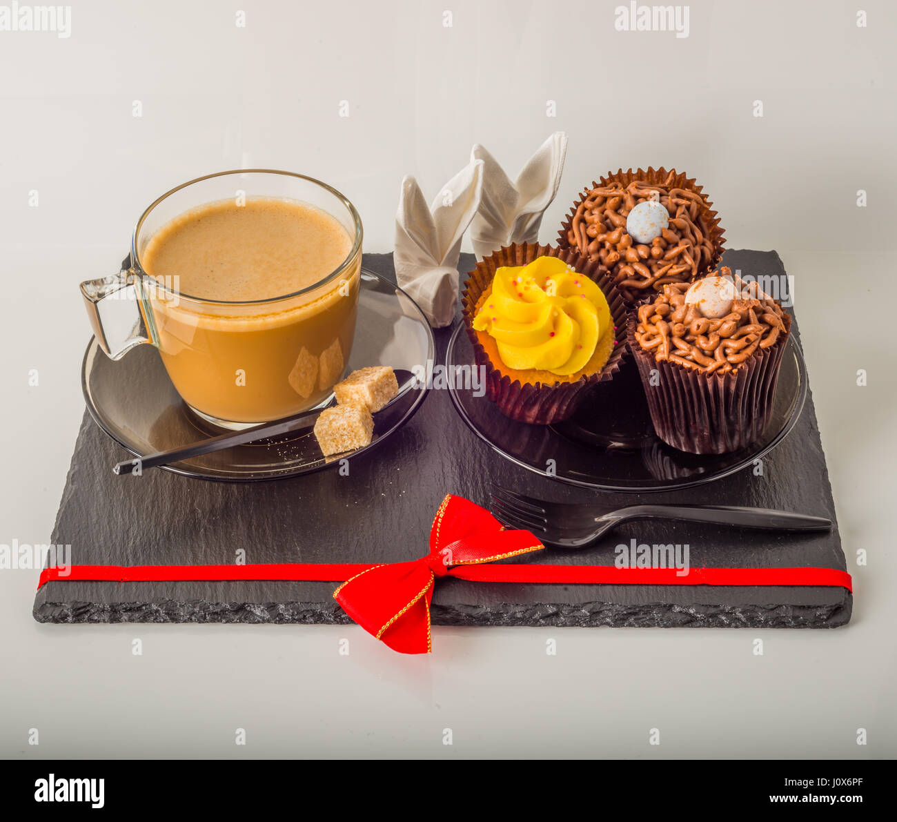 White coffee in modern glass cup, muffins with Easter decoration, red ...