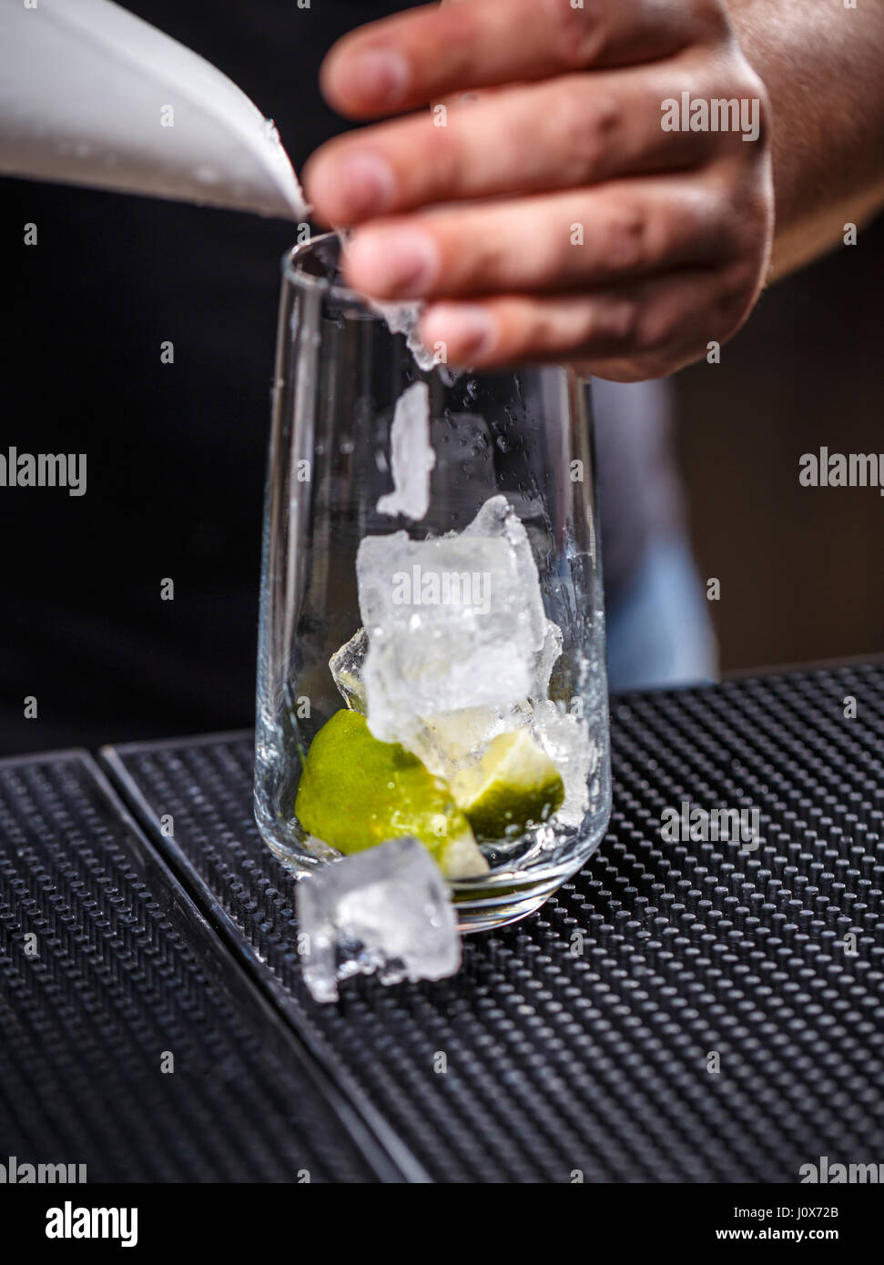 Glass filled with ice cubes. Bartender preparing cocktail Stock Photo ...