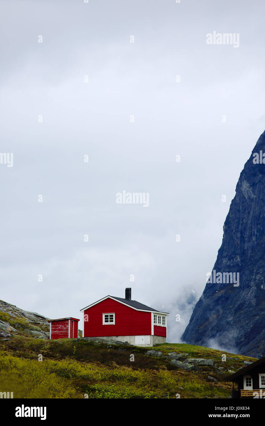 Typical red Norwegian house between high mounatins in summer Stock ...