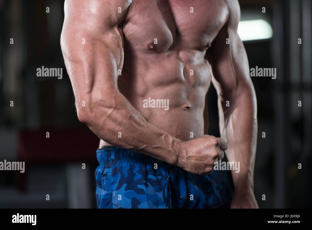 Healthy Man Standing Strong In The Gym And Flexing Muscles - Muscular ...