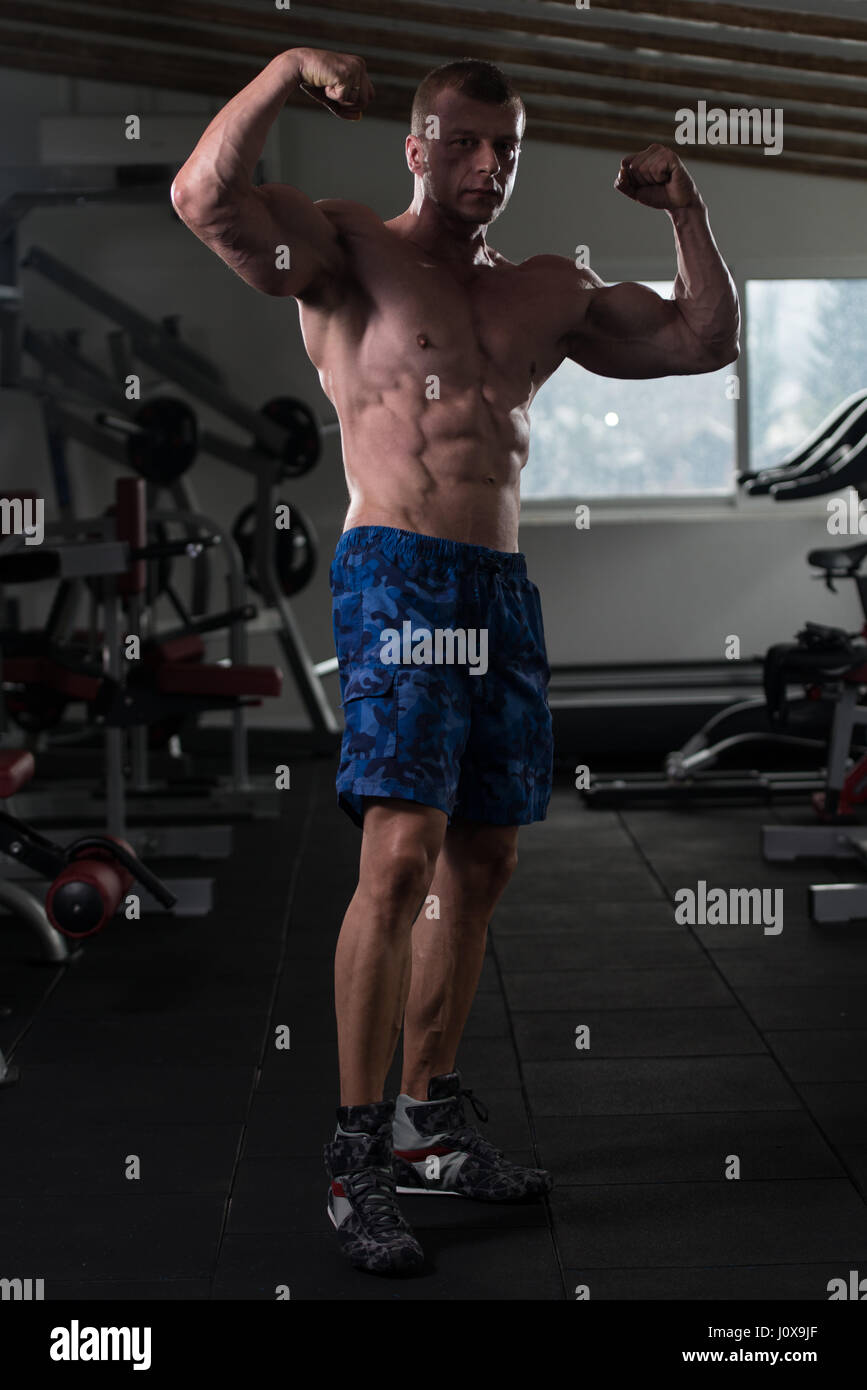 Healthy Man Standing Strong In The Gym And Flexing Muscles - Muscular ...