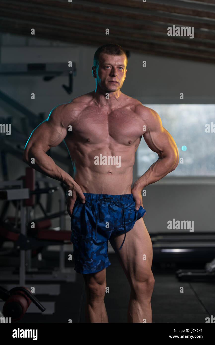 Healthy Man Standing Strong In The Gym And Flexing Muscles - Muscular ...