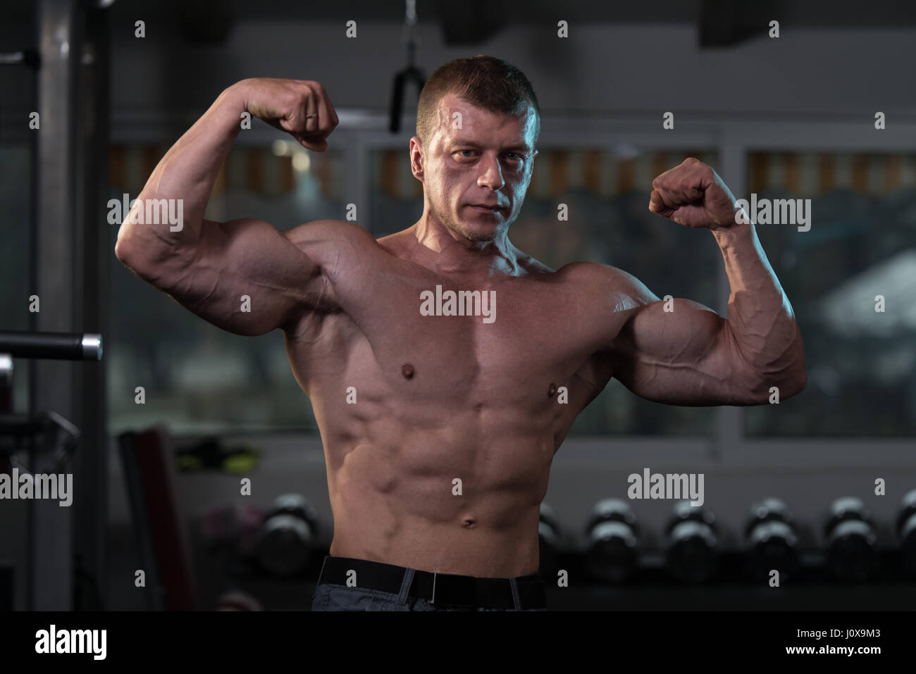 Healthy Man Standing Strong In The Gym And Flexing Muscles - Muscular ...