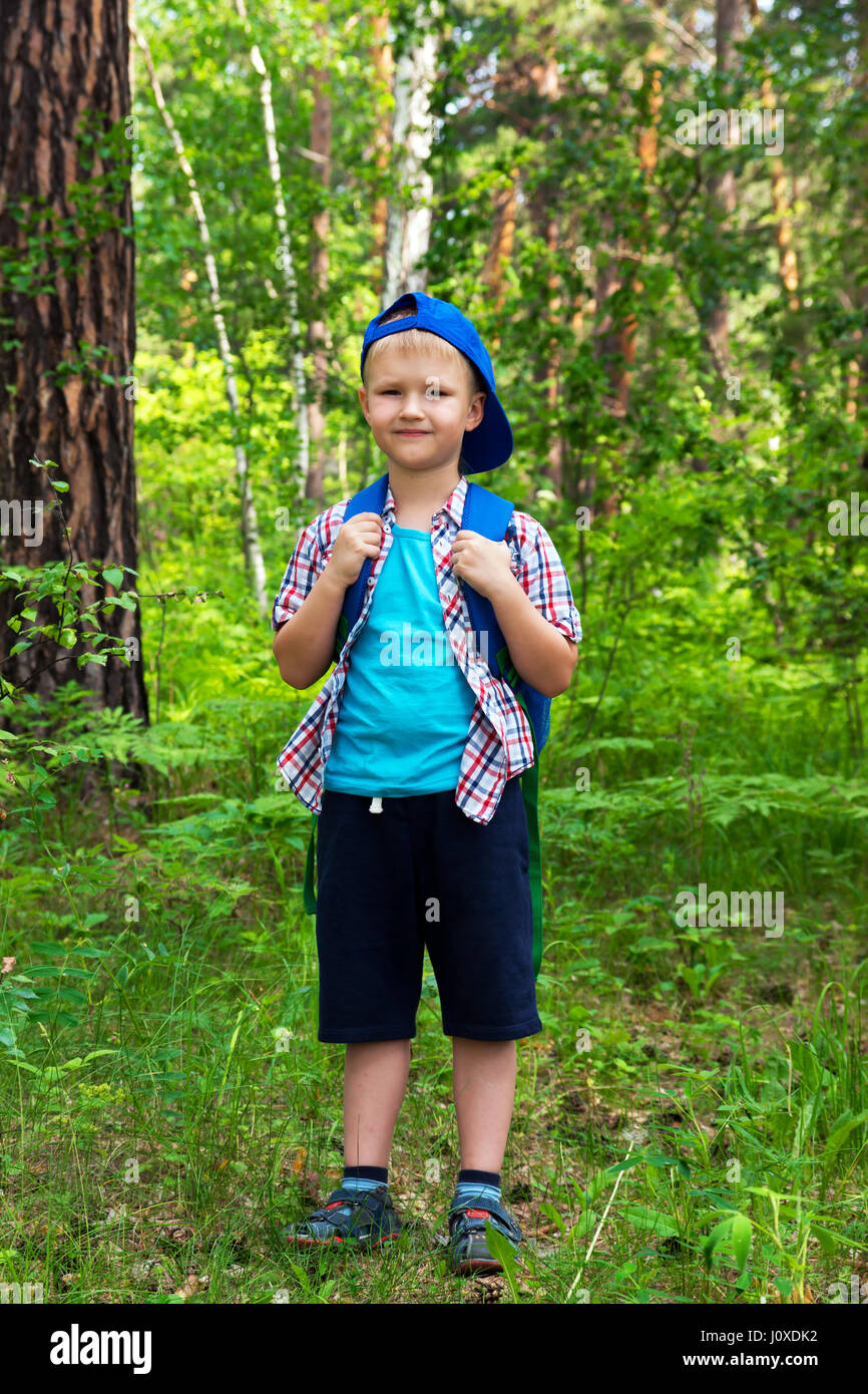 Young happy boy (child) walking outdoor with backpack, having fun in ...