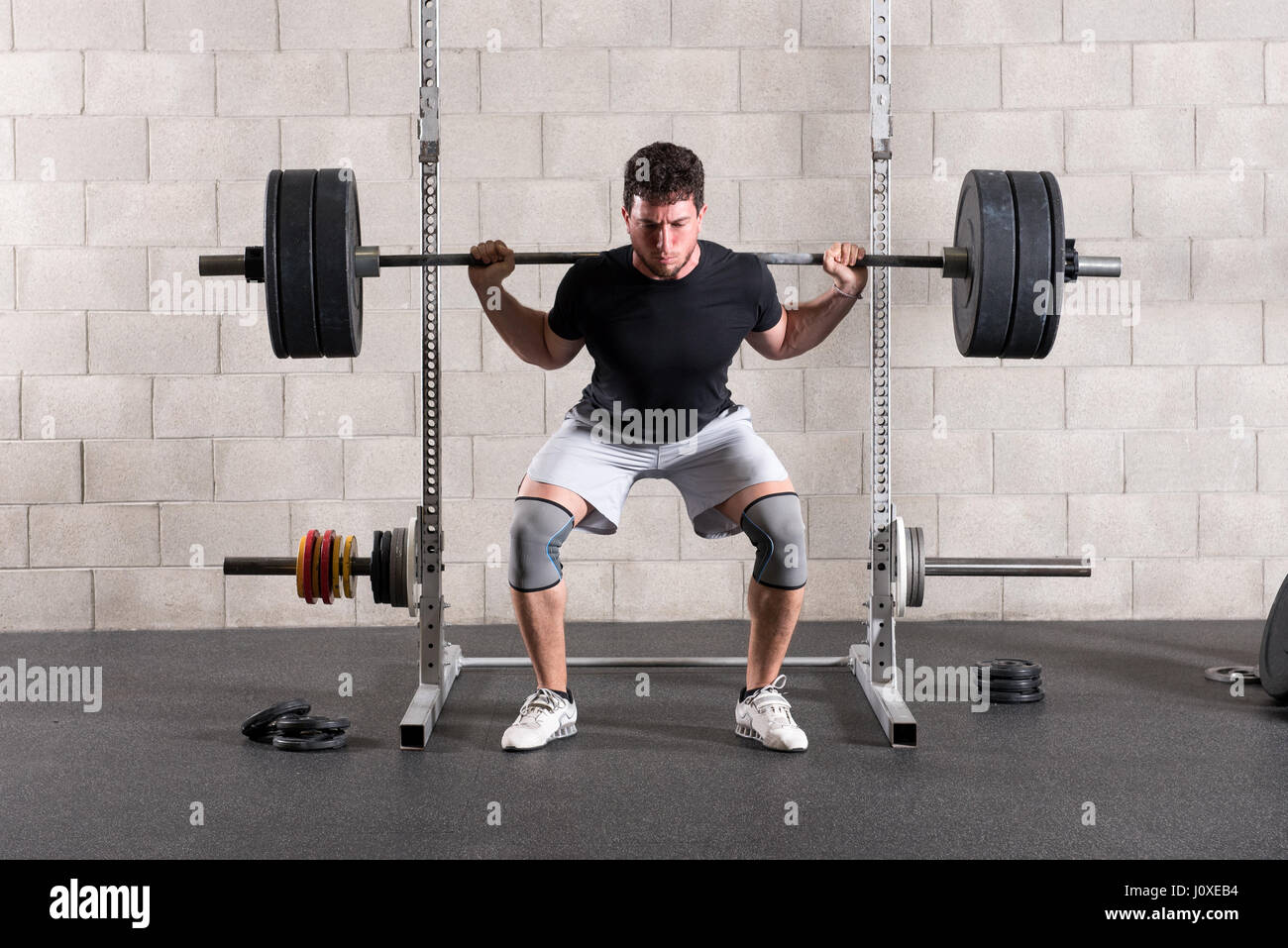 Man performing a crossfit back squat exercise slowly raising himself ...