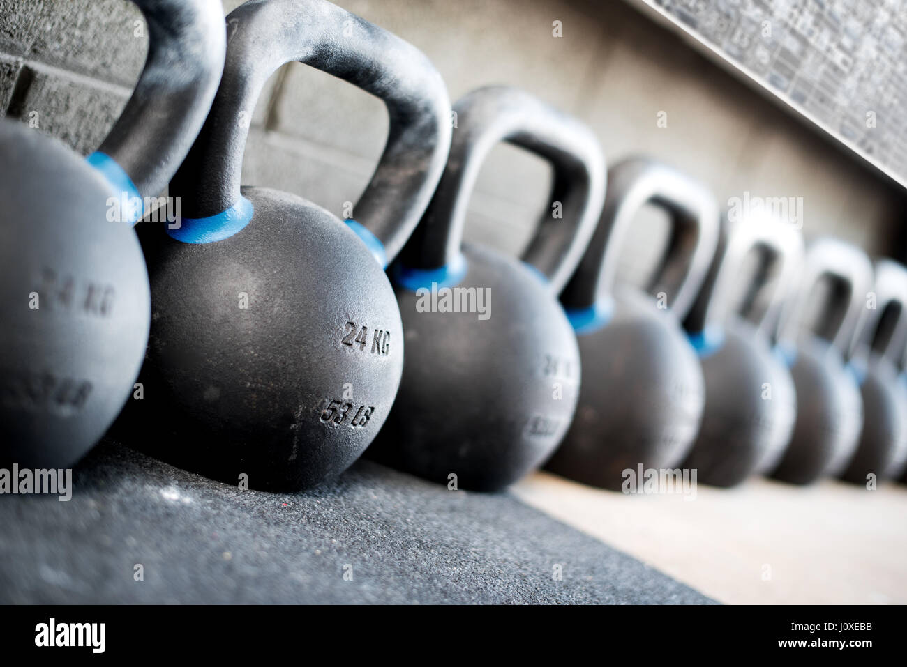 Row of kettlebell or girya weights in a gym with selective focus to a ...